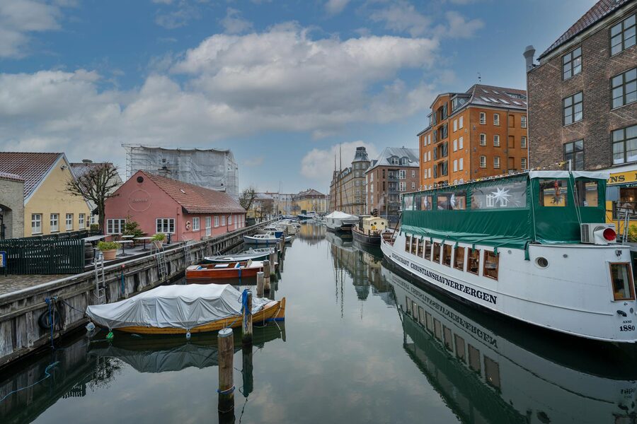 Copenhagen canal with historic buildings and moored boats on both sides
