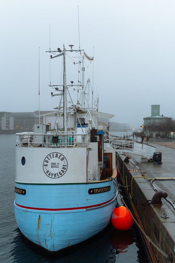 Blue fishing vessel in foggy Copenhagen harbour