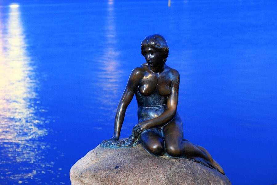 The Little Mermaid statue at Copenhagen harbour with blue water