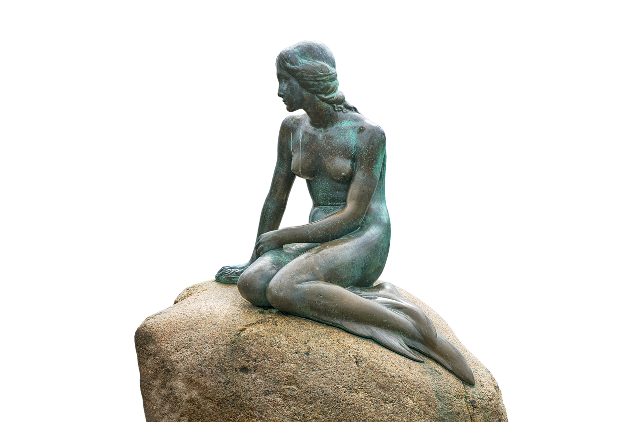 The Little Mermaid bronze statue sitting on her rock by the sea in Copenhagen