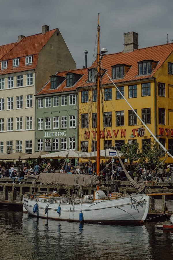 Vintage sailboat moored at Nyhavn with historic Copenhagen buildings