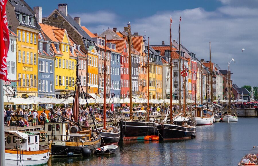 Summer view of Nyhavn canal with colorful townhouses and moored boats