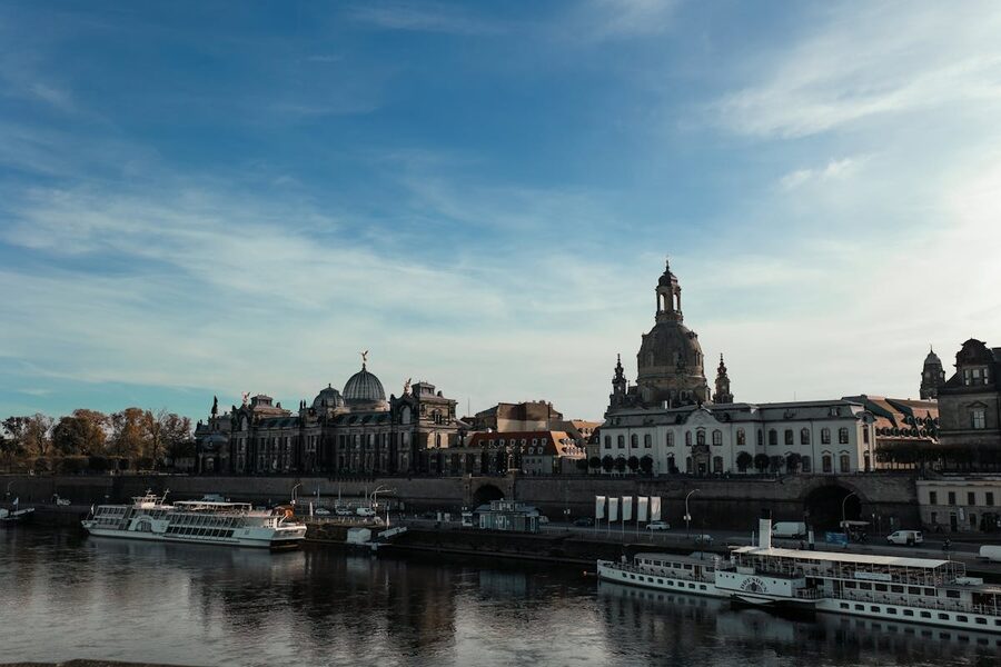 Dresden skyline featuring historic architecture along the Elbe River with boats