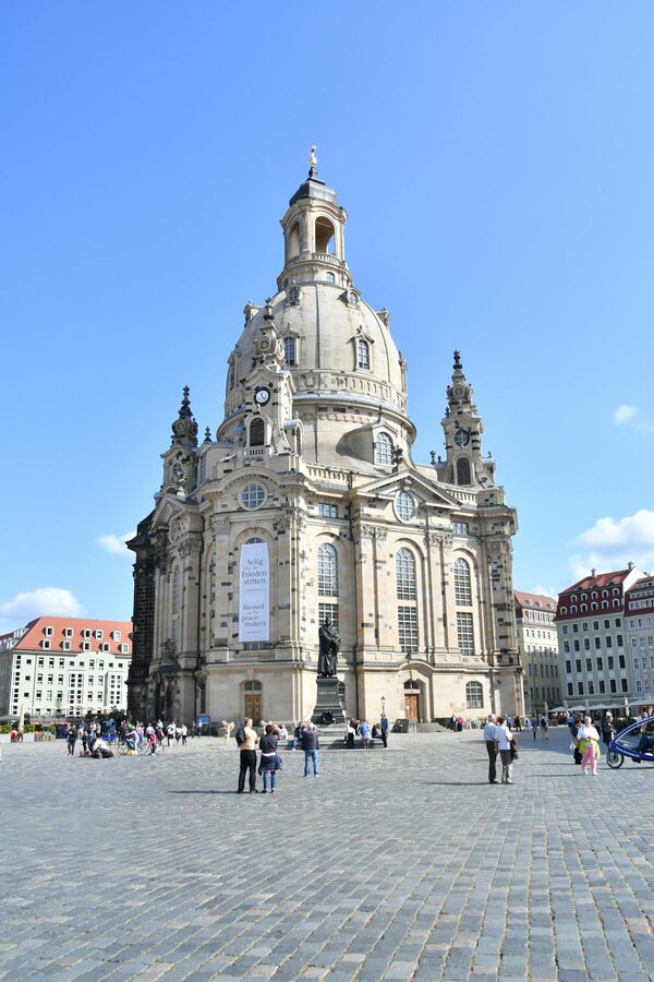 Frauenkirche in Dresden with travelers under clear blue sky