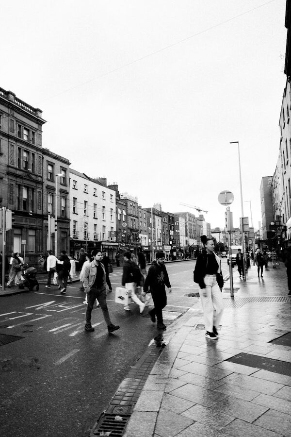 Busy shopping street in Dublin with pedestrians and historic buildings
