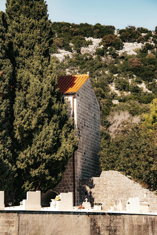 Stone building with red roof in lush greenery Lopud Croatia