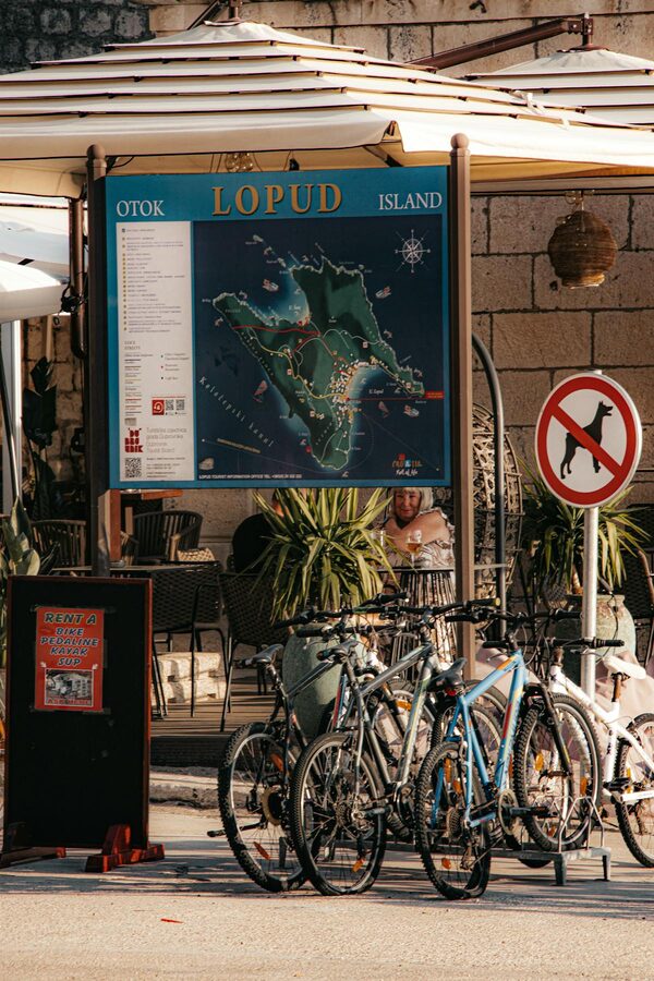 Bicycles parked under map sign on Lopud Island