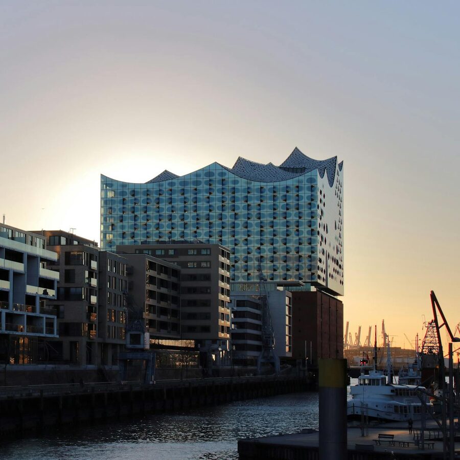 Elbphilharmonie building at sunset with warm light reflecting off the glass facade