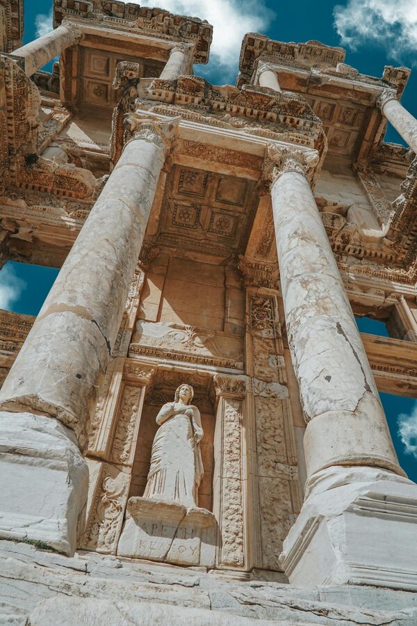 Looking up at the Corinthian columns of the Library of Celsus against a blue sky