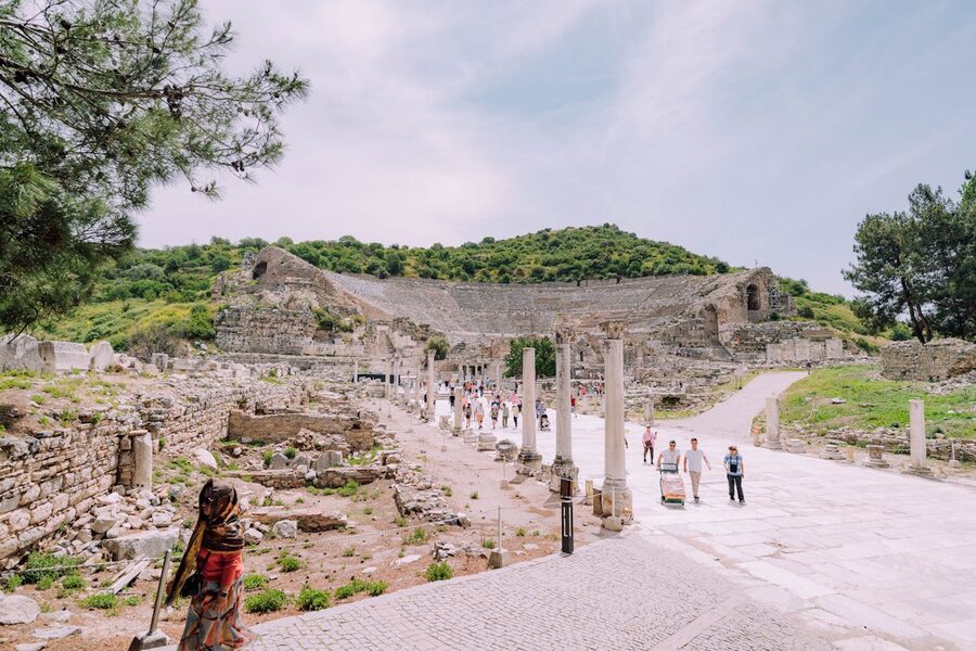 Tourists exploring the ancient theater at Ephesus on a sunny day