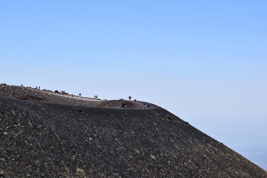 Etna explorers hiking rugged volcanic terrain
