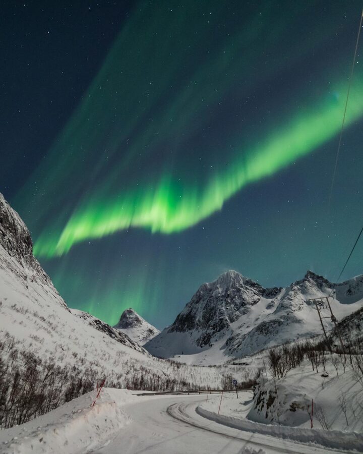 Northern Lights over snow-covered mountains in Lapland