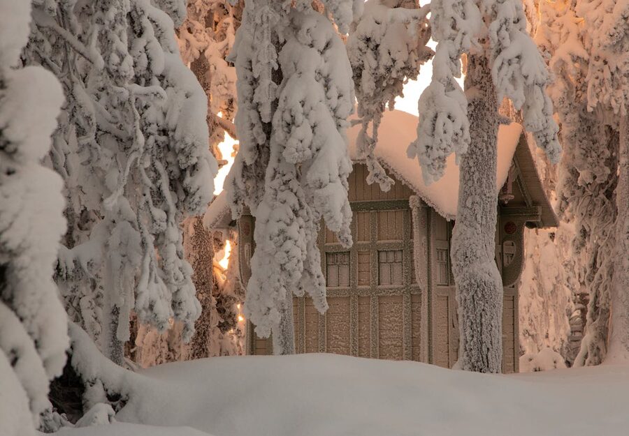A wooden cabin buried in snow in the Finnish Lapland wilderness