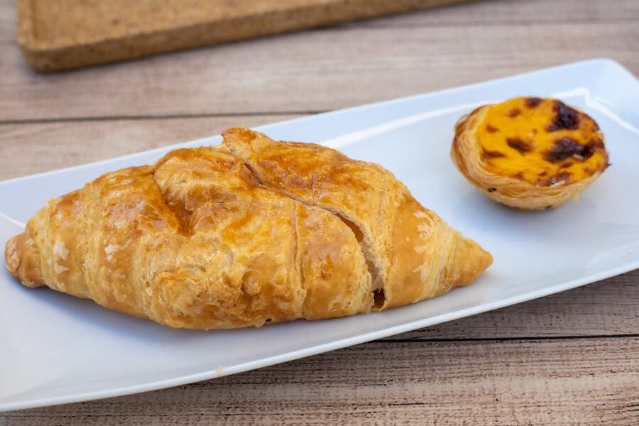 Golden croissant and pastel de nata on plate