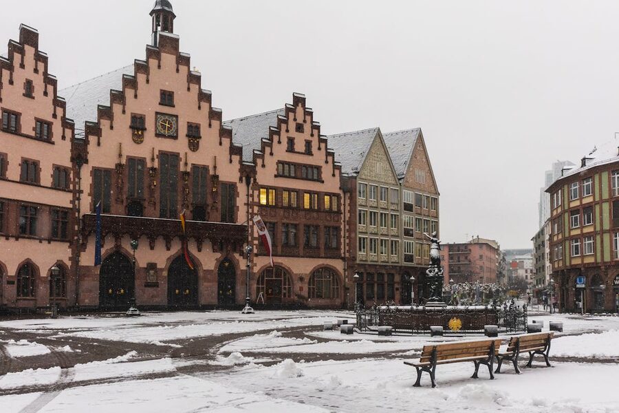 Snow-covered Römer Square in Frankfurt with historic buildings and fountain