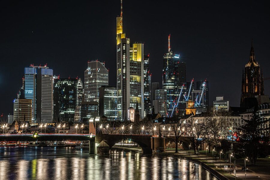Frankfurt skyline at night with illuminated skyscrapers reflected in Main River