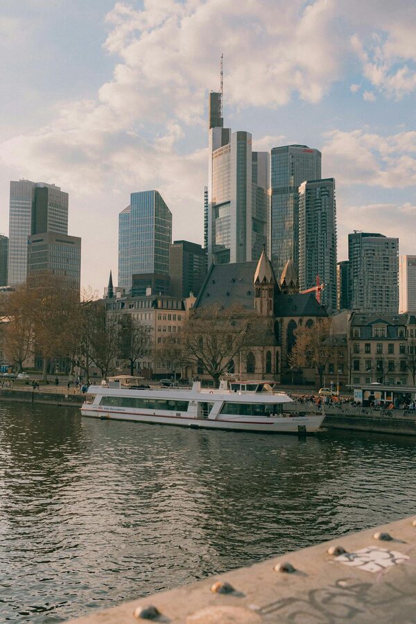 Frankfurt skyline at sunset with skyscrapers and Main River glowing orange