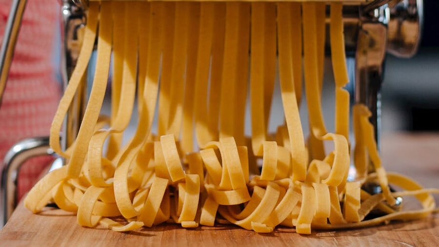 Fresh pasta strands being cut