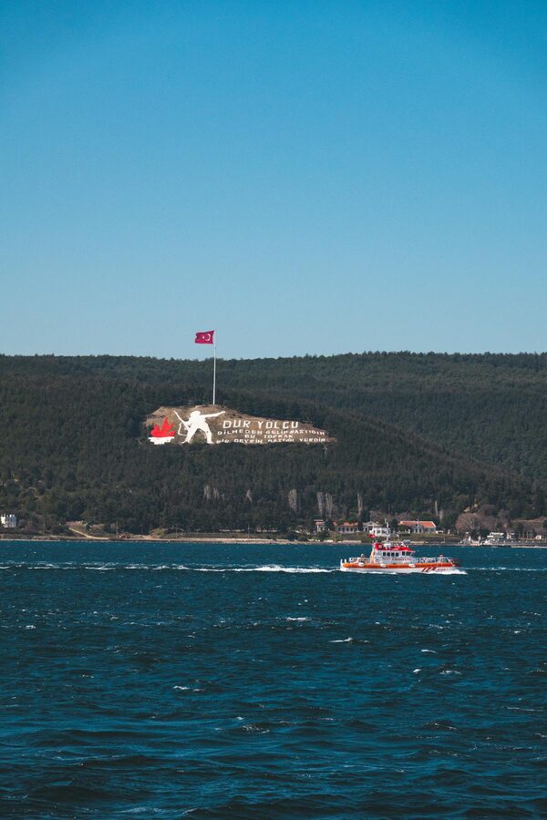 Ferry boat crossing the Dardanelles near forested green hills