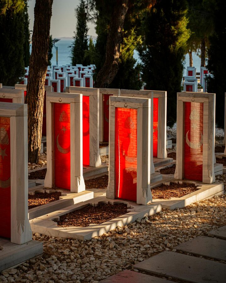 Monuments and Turkish flags at the Canakkale Martyrs Cemetery in sunlight