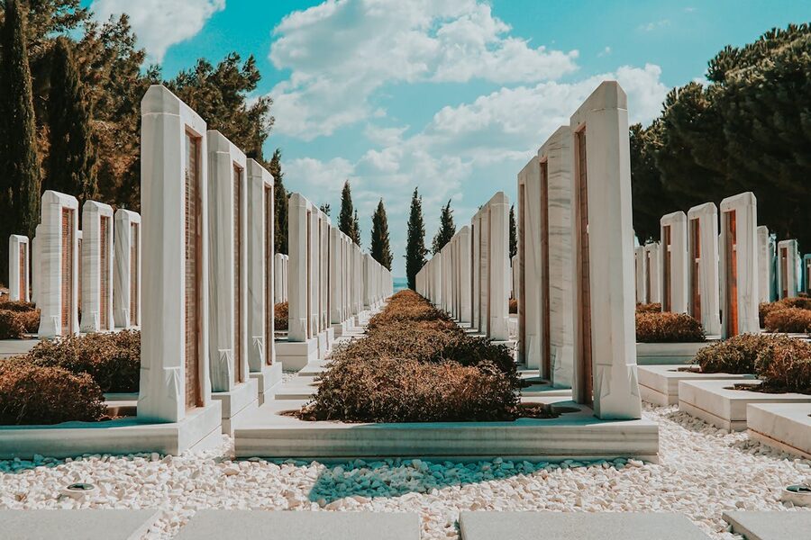Rows of white marble tombstones under blue sky at Canakkale military cemetery