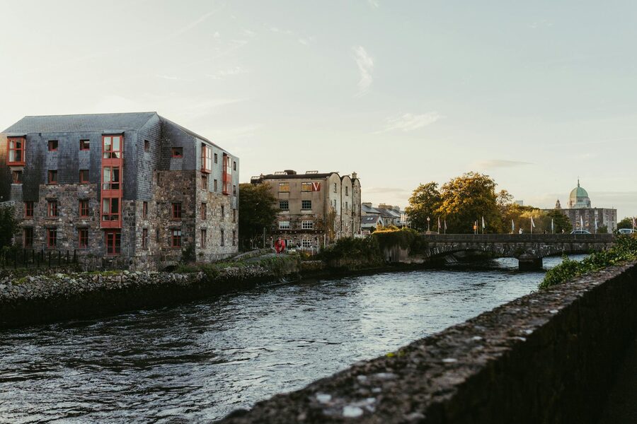 Galway city river at sunset with colourful buildings reflected in the water