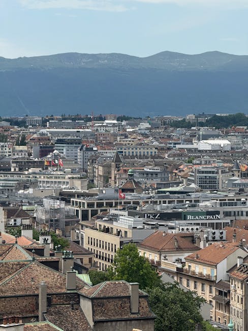 Aerial view of Geneva city with mountains in the distance under clear skies