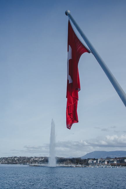 Lake Geneva view with Swiss flag in the foreground and the Jet d'Eau rising in the background