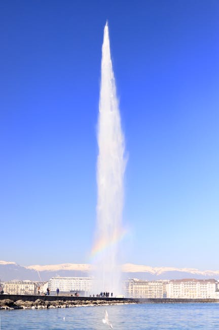 Jet d'Eau fountain in Geneva shooting water high into the air with a rainbow formed in the spray