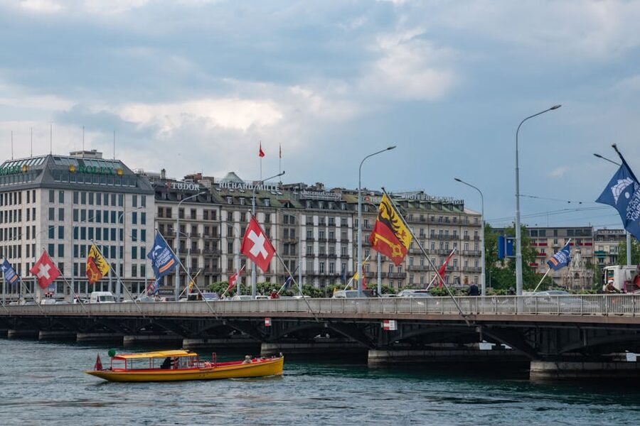 Mont-Blanc Bridge in Geneva with flags flying and the city skyline behind it