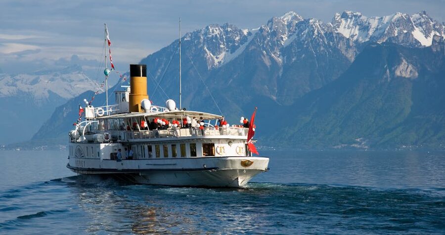 Historic paddle steamer cruising on Lake Geneva with the Swiss Alps in the background