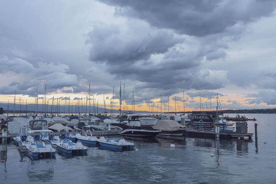 Geneva port at sunset with sailboats moored and golden light on the water