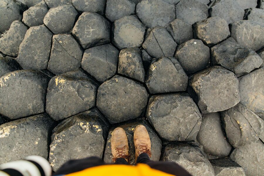 Boots standing on hexagonal basalt columns at Giants Causeway