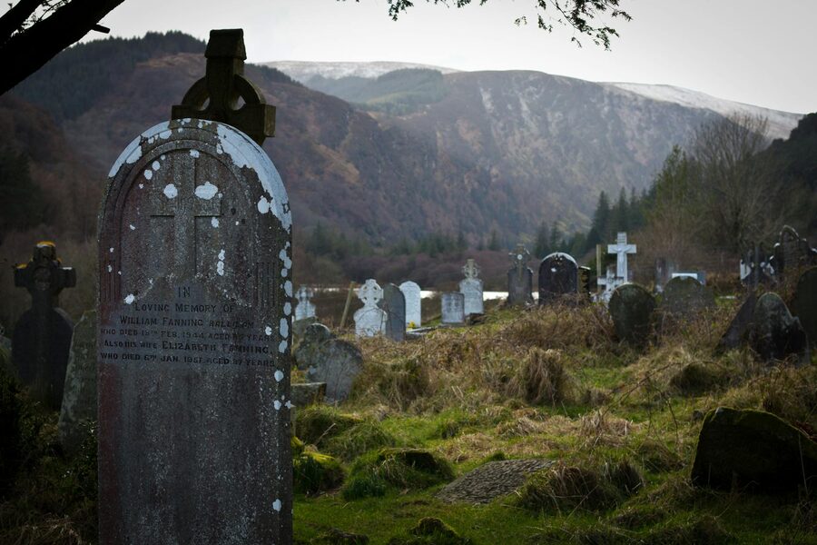 Historic cemetery at Glendalough surrounded by mountains and trees