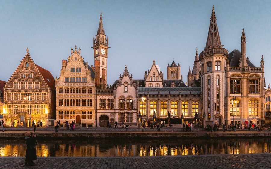 Ghent medieval buildings illuminated at twilight along canal
