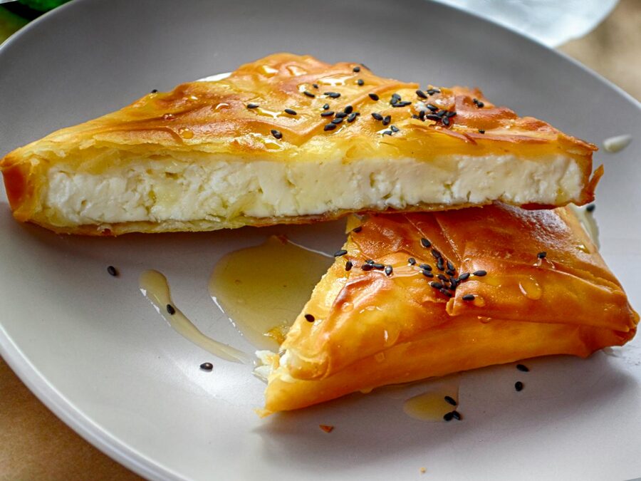 Greek cheese pie drizzled with honey and sesame seeds
