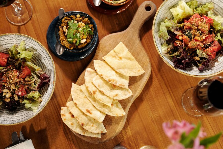 Traditional Greek mezze platter with pita, salads and wine