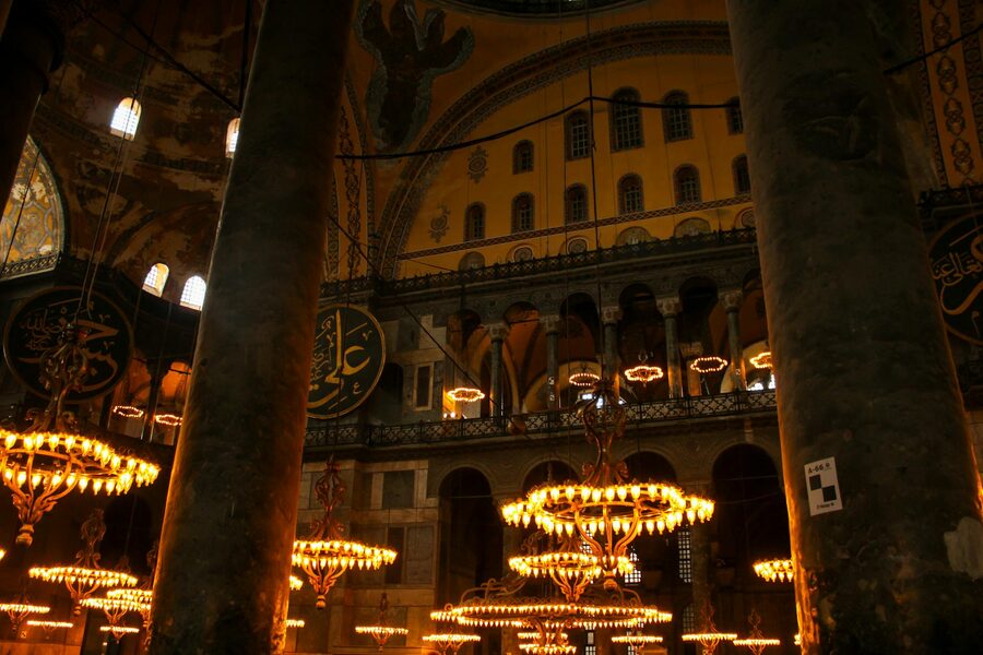 Grand interior of Hagia Sophia with ornate chandeliers and architectural details