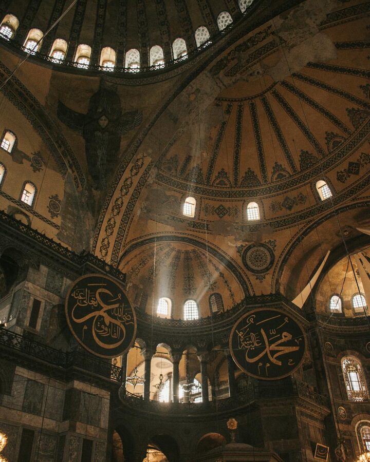 Sunlight streaming through the dome of Hagia Sophia highlighting Islamic calligraphy
