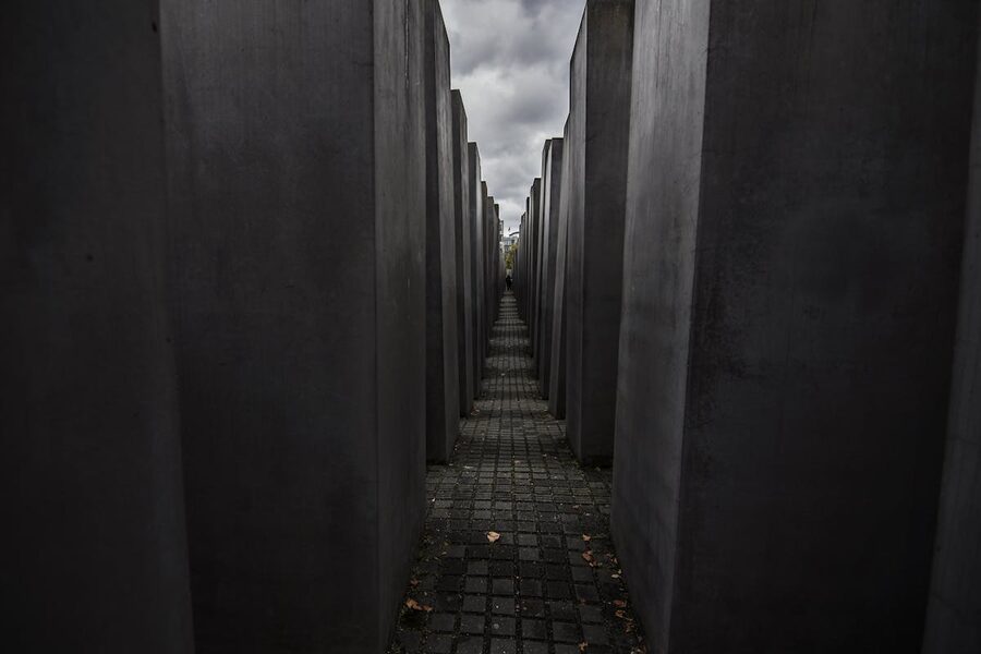 Holocaust Memorial stelae in Berlin under dramatic cloudy sky
