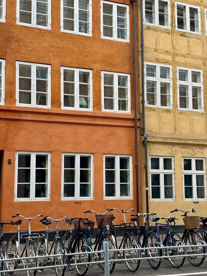 Bicycles lined up against colourful buildings on a Copenhagen street