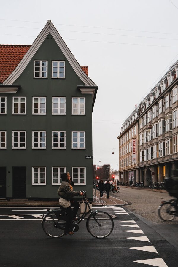 Cyclist passing historic buildings on a Copenhagen street