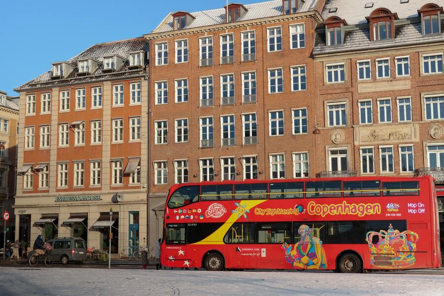 Red sightseeing bus in front of Copenhagen architecture in winter