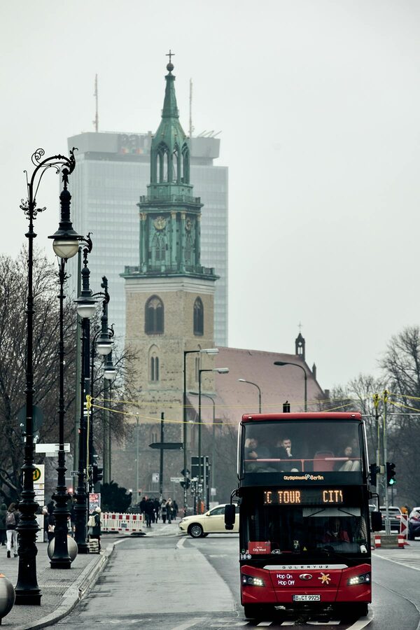 Street view of central Berlin with historic church and city tour bus