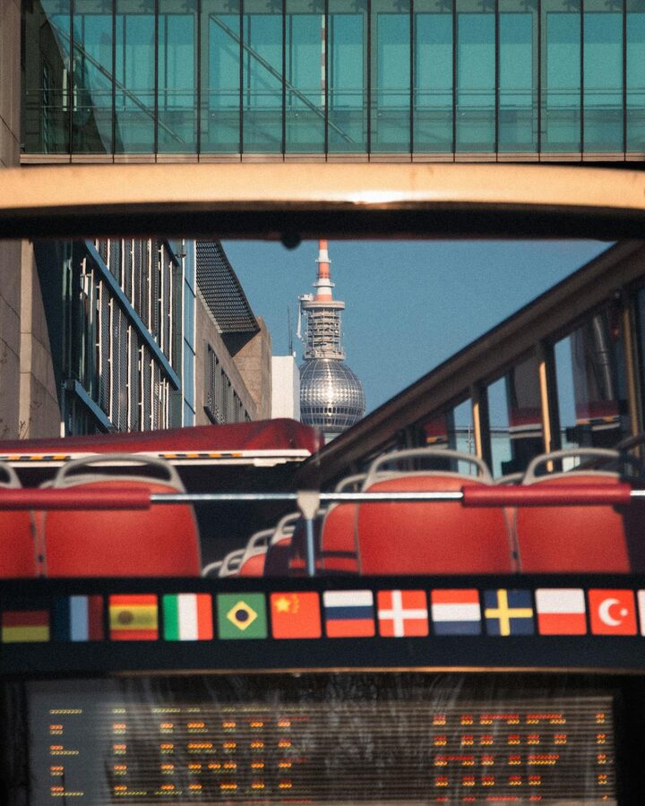 Berlin TV Tower framed by open-top bus and modern architecture