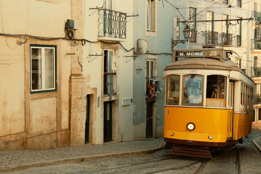 Classic yellow Lisbon tram on narrow street