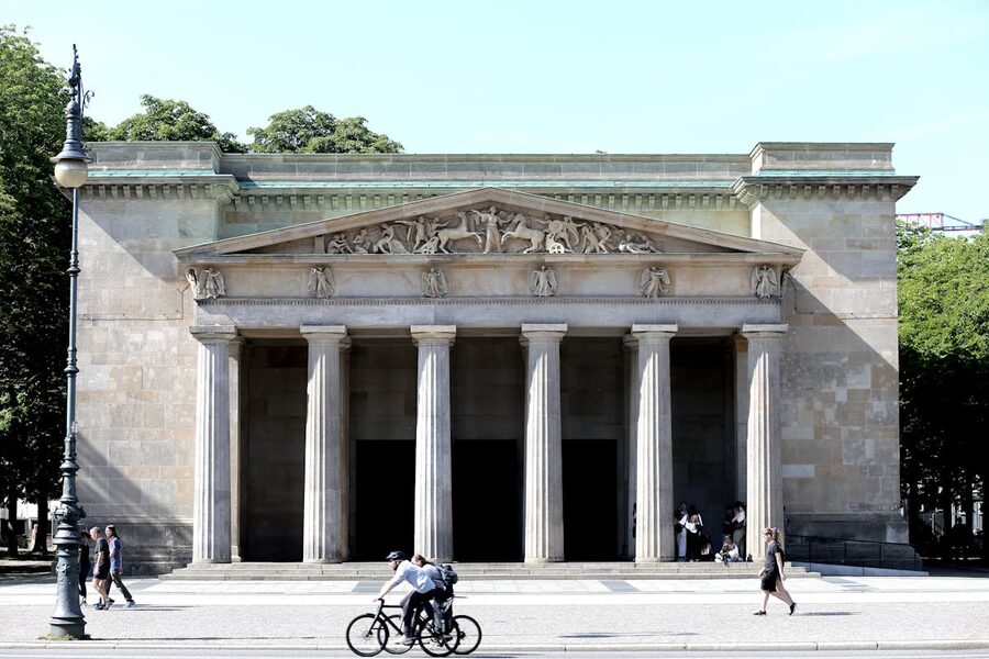 Neue Wache memorial building in Berlin with visitors on a sunny day