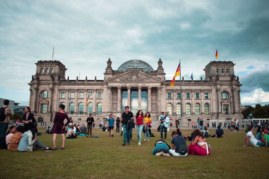 Tourists relaxing on lawn in front of the Reichstag Building in Berlin