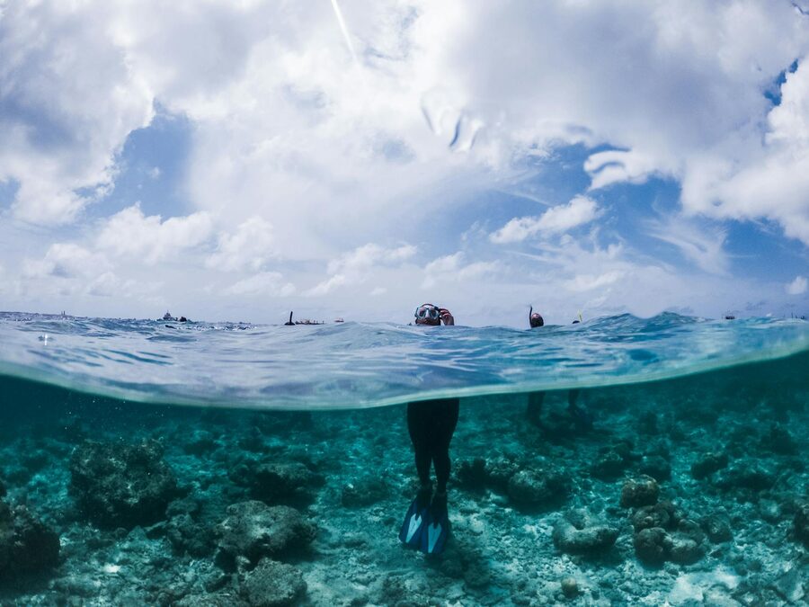 Snorkeler standing in warm blue seawater