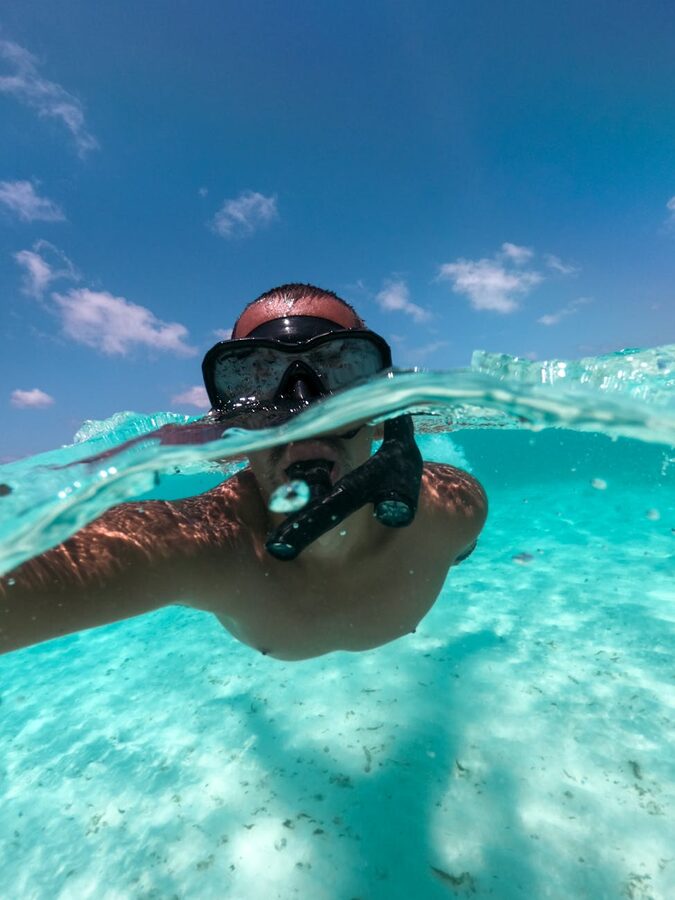 Man snorkeling in clear blue water